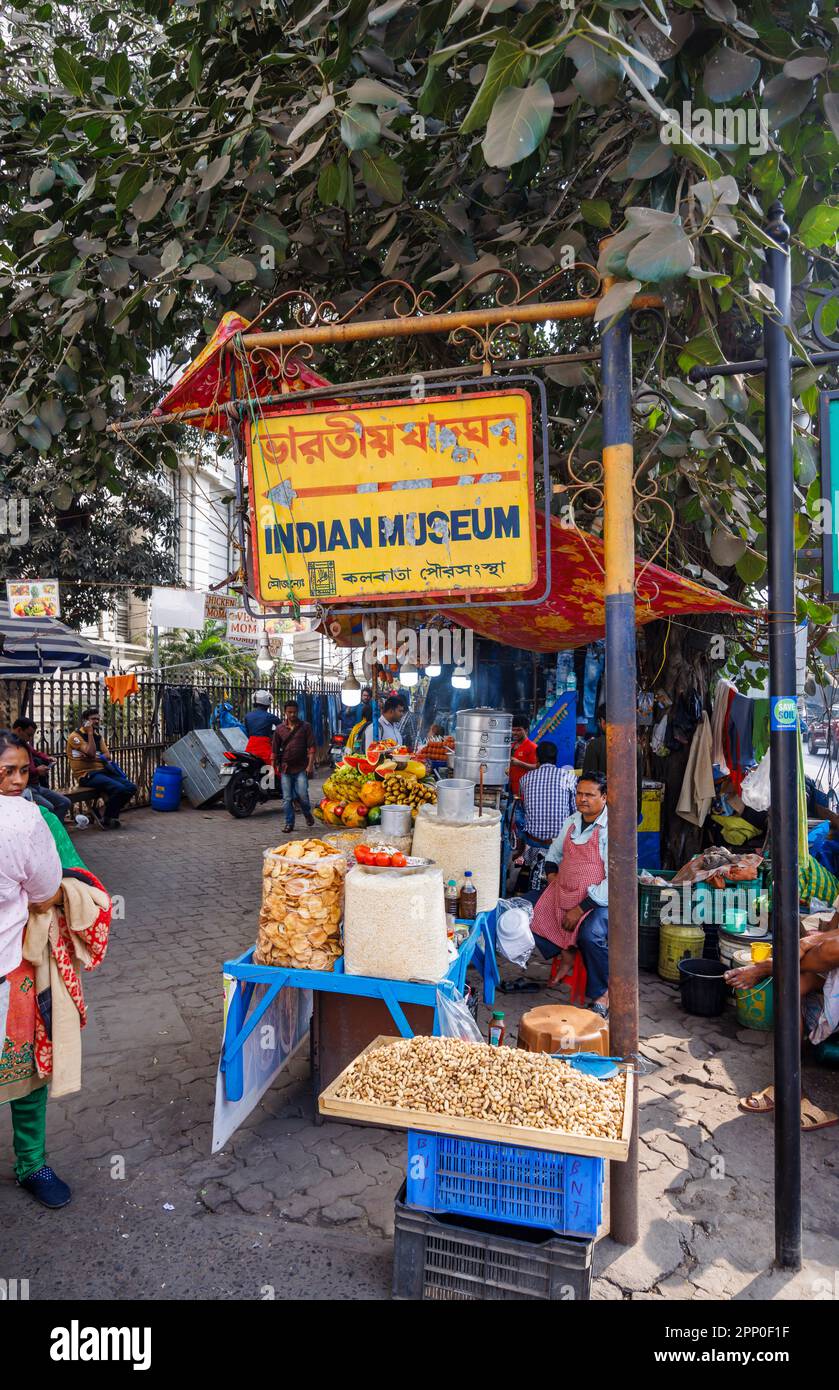 Name sign and street food stall seller by the entrance of the Indian ...