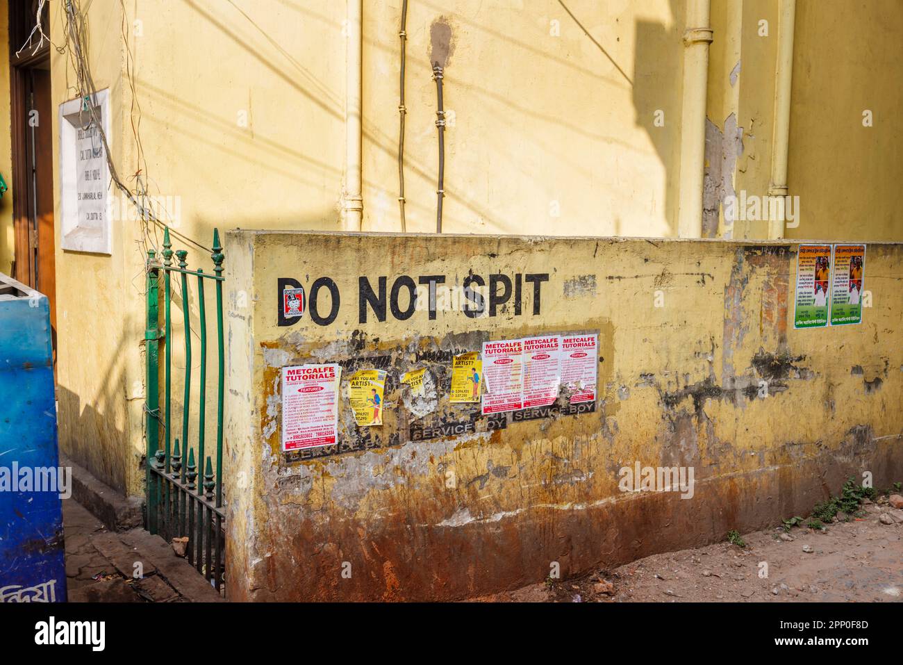 A 'Do Not Spit' sign painted on a roadside wall in the New Market Area ...