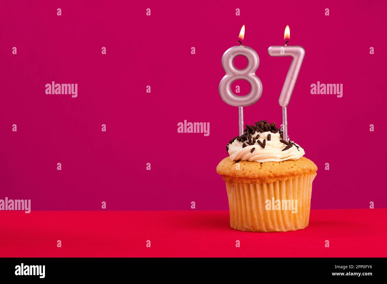 Birthday cake with candle number 87 - Rhodamine Red foamy background ...