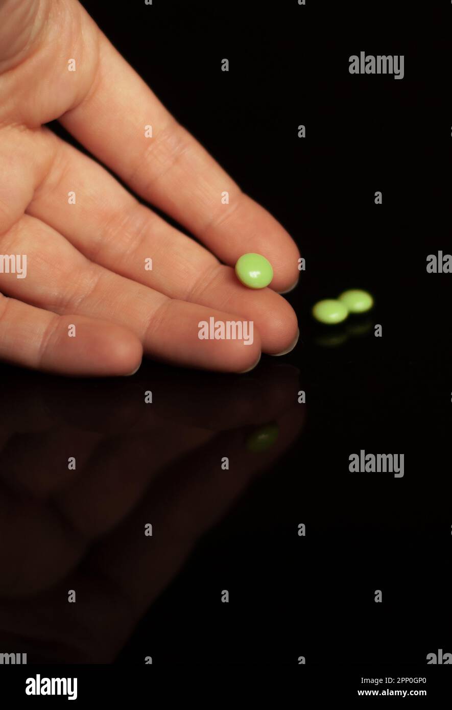 View of two pills on the black background Stock Photo - Alamy