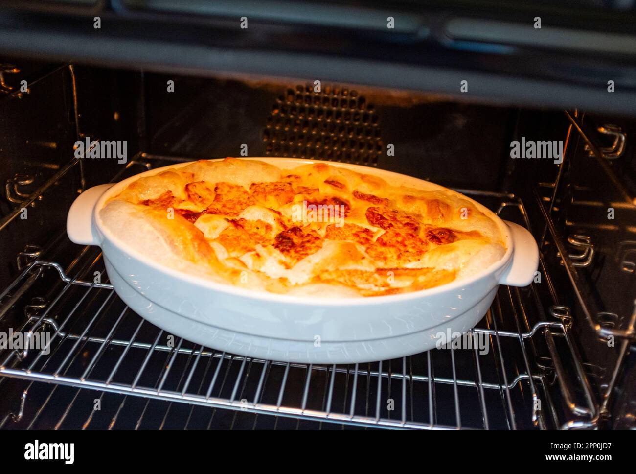 Pomme Dauphinoise cooking in a hot electric fan oven Stock Photo - Alamy