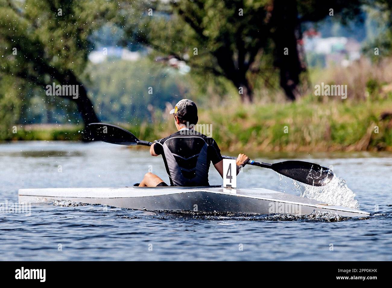 rear view male athlete on kayak single rowing training on lake Stock ...