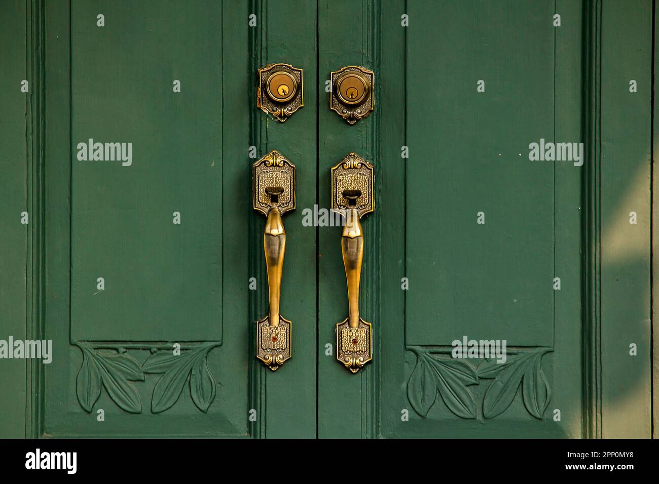 Door Handles Old brass on the green door Used to close or open the door ...