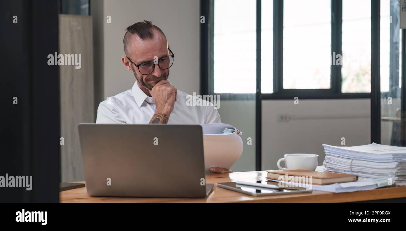 Serious financier accountant on paper work inside office, mature man ...
