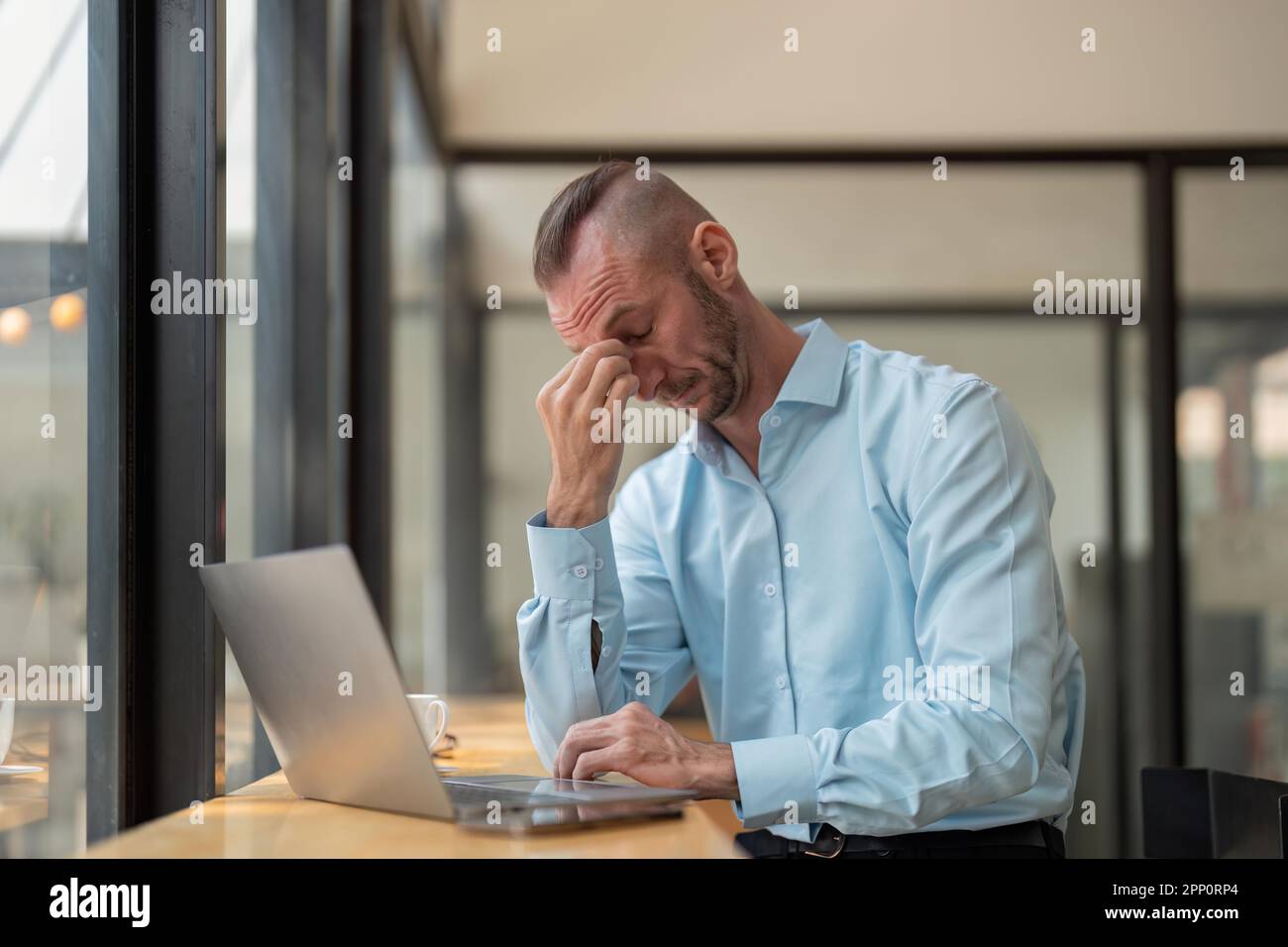 Stressed business man sitting at office workplace. Tired and overworked ...