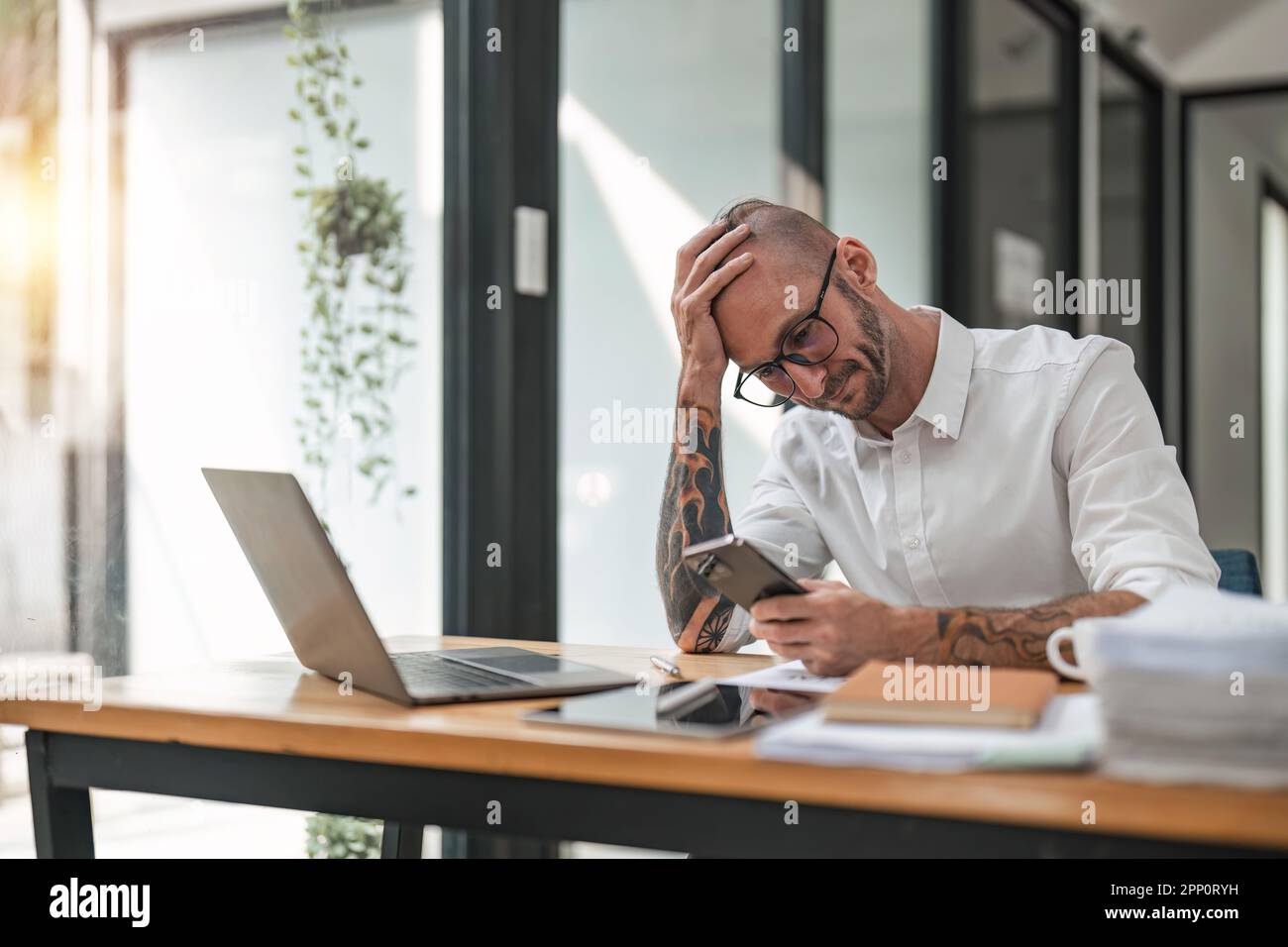 Stressed business man sitting at office workplace. Tired and overworked ...