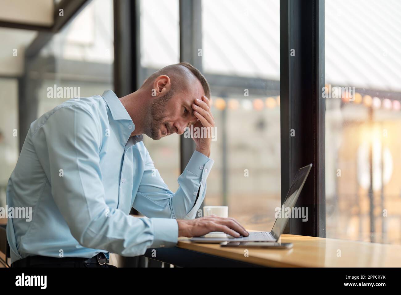 Stressed business man sitting at office workplace. Tired and overworked ...