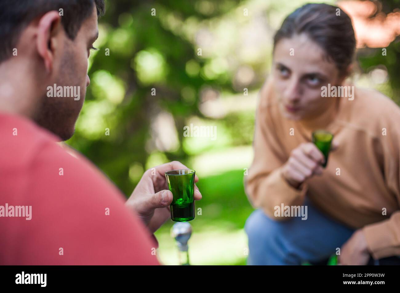 Very drunk couple, a boy and a girl, drink a strong alcoholic drink ...