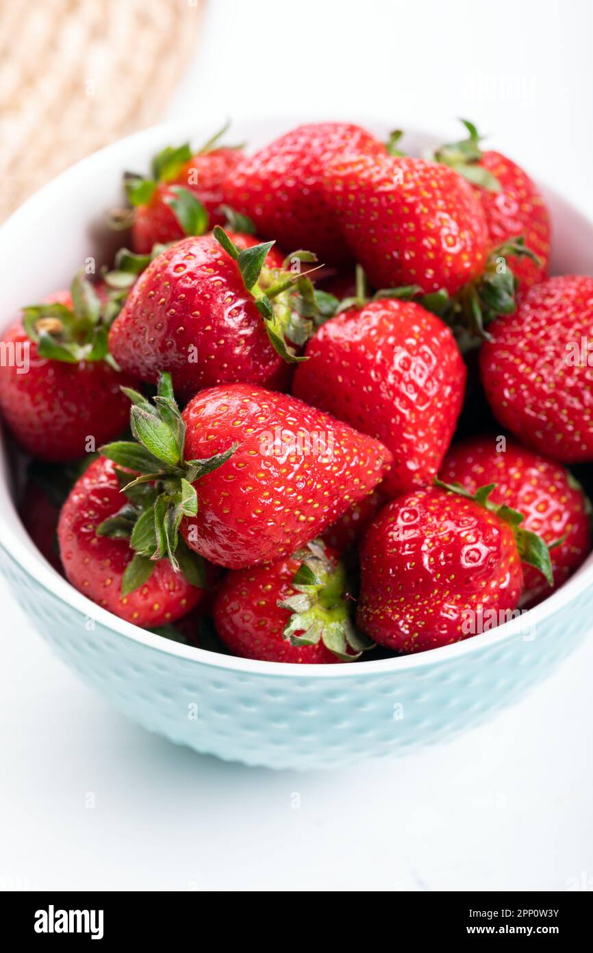 Fresh strawberries in a blue ceramic bowl, on a wicker background Stock ...