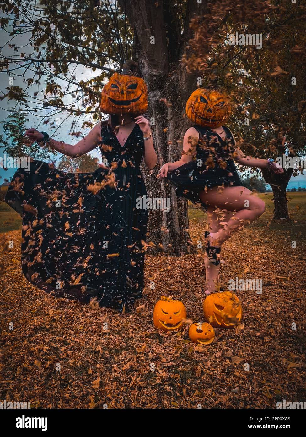 Two female friends joyfully celebrating the Halloween season by jumping ...