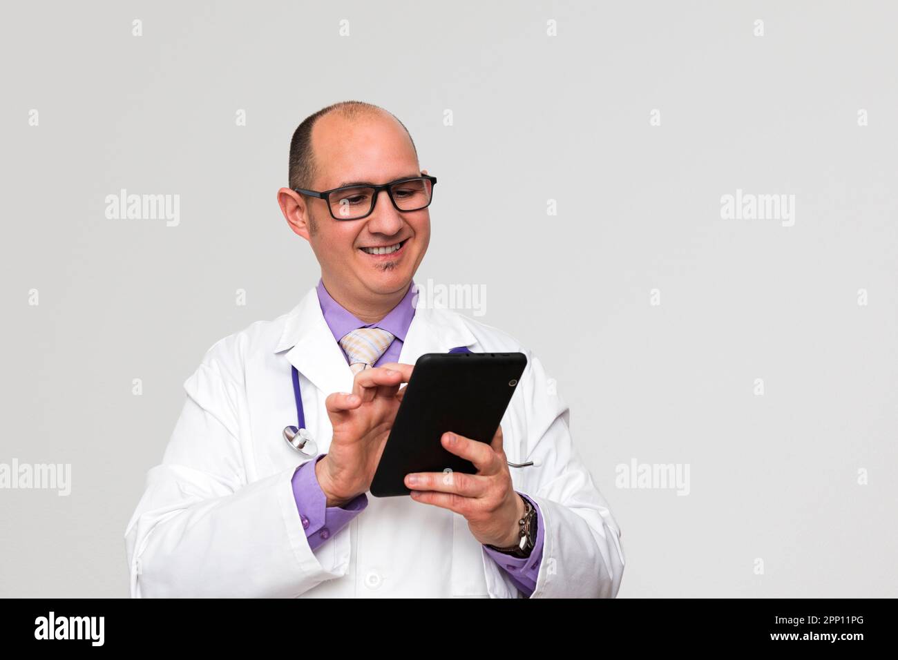 A bald male smiling caucasian doctor with eyeglasses wearing a white ...