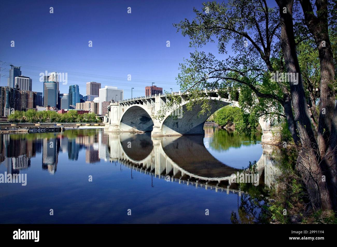 The Third Avenue Bridge reflects in a calm Mississippi River in ...