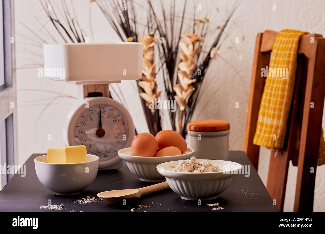 Baking products set out on a table in a kitchen next to a window with ...