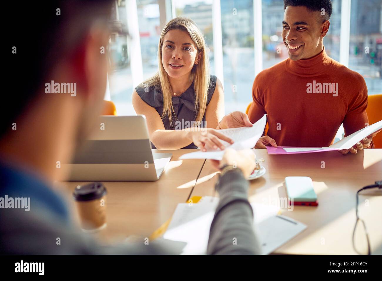 Close-up of young colleagues in a commission talking to a male ...