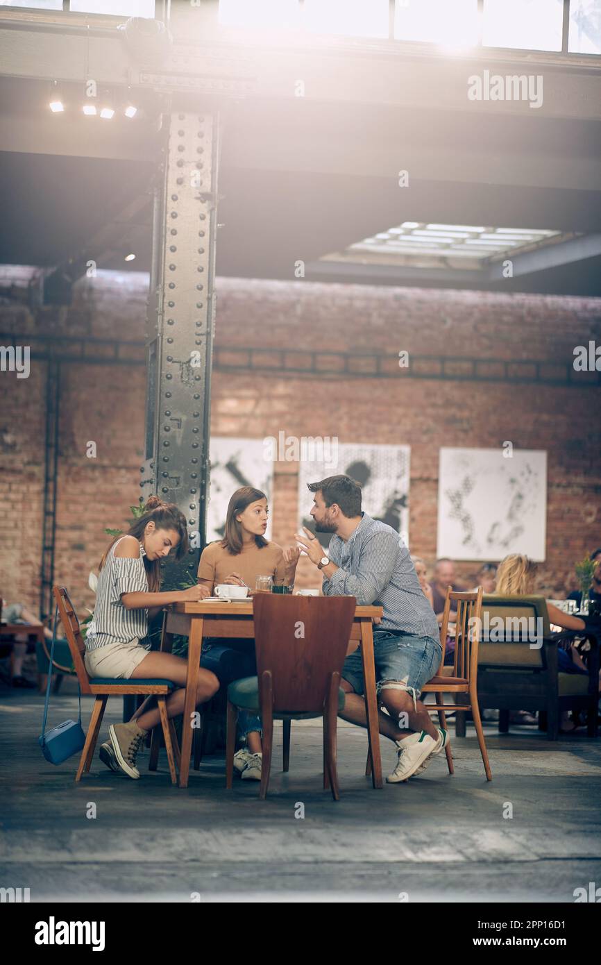 Young students on a coffee break, discussing something and writing ...