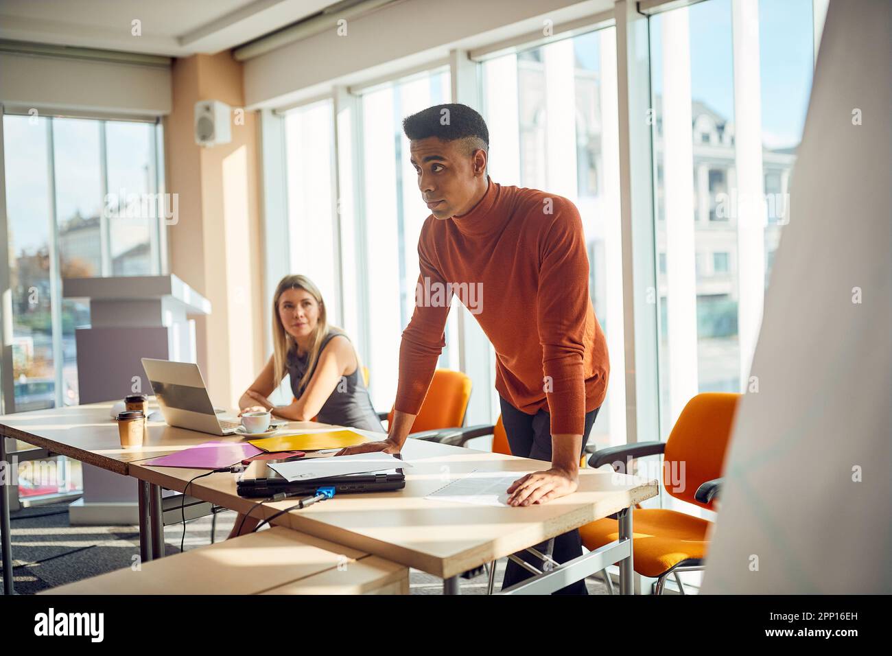 Young male lecturer giving a business lecture in a pleasant atmosphere ...