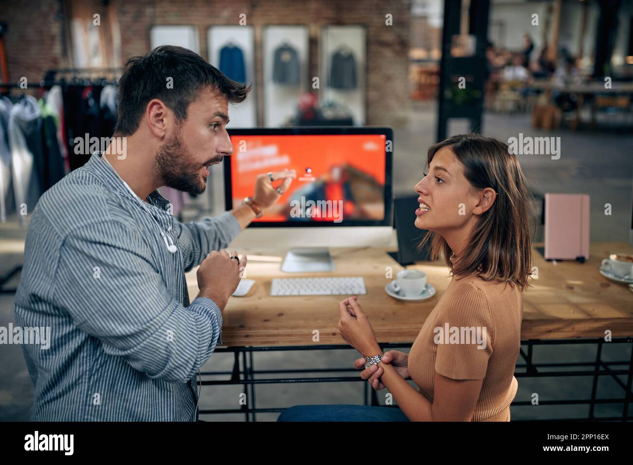 Man and woman having serious conversation at work, in front of desktop ...