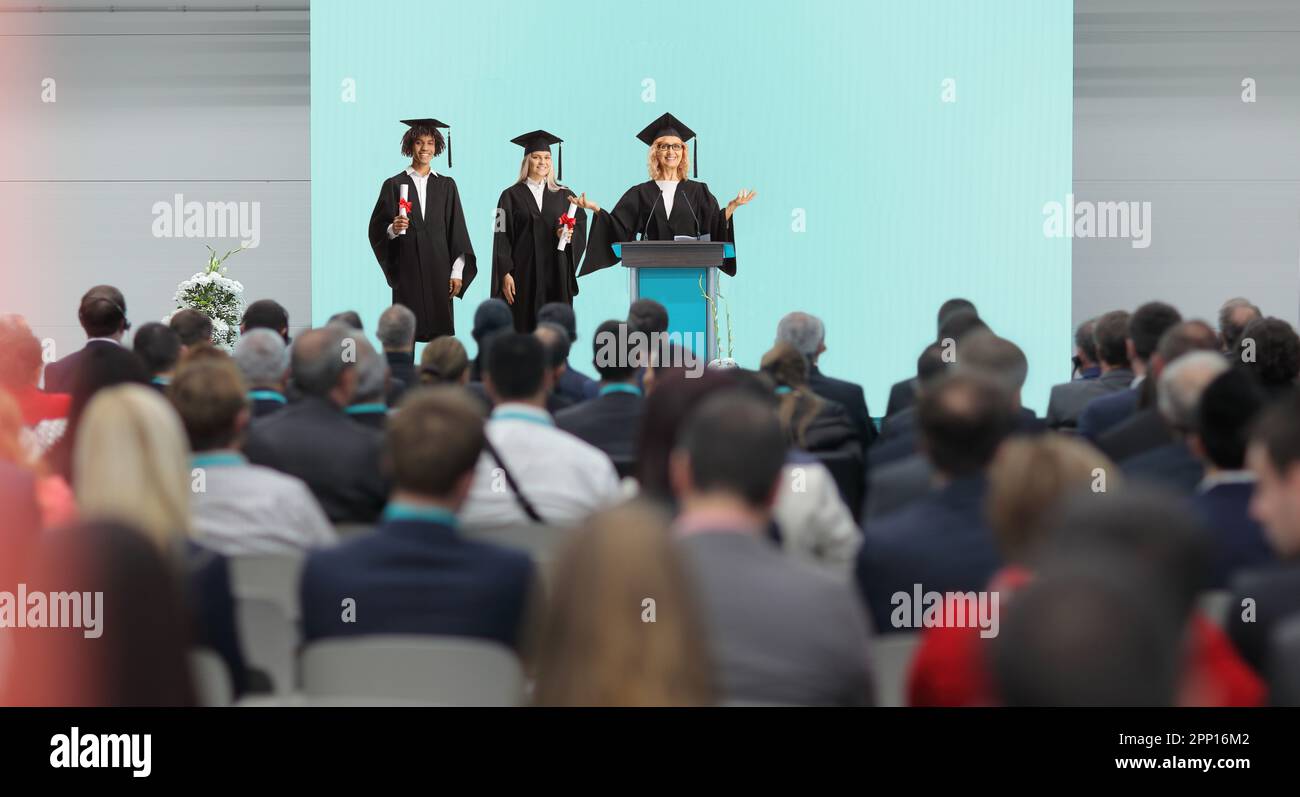 Graduate students of honor and a professor standing on a podium in ...