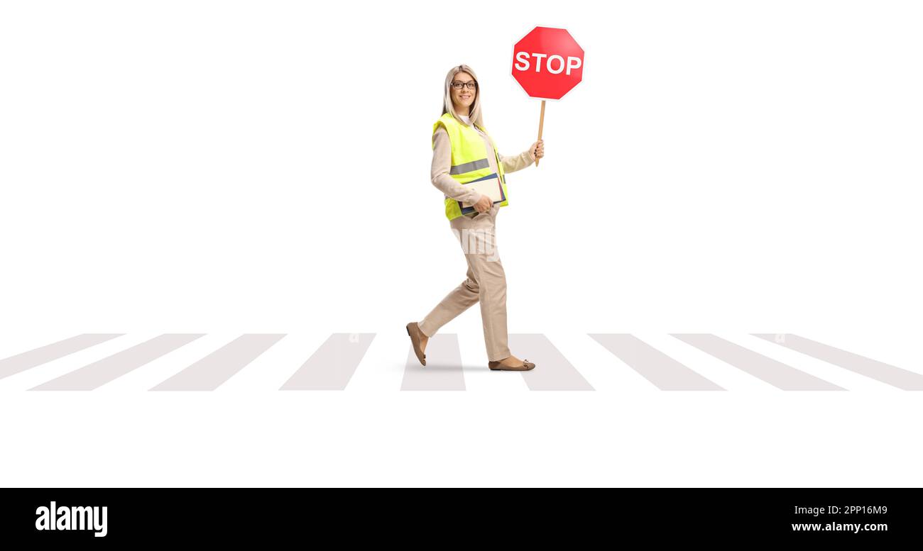 Full length shot of a young woman walking at a pedestrian crossing with ...