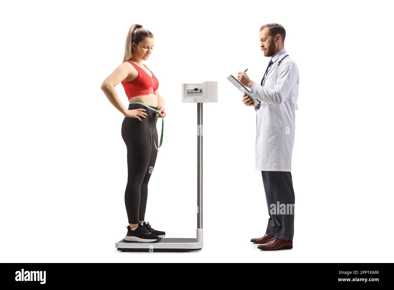 Doctor checking weight of a young woman in sportswear isolated on white ...