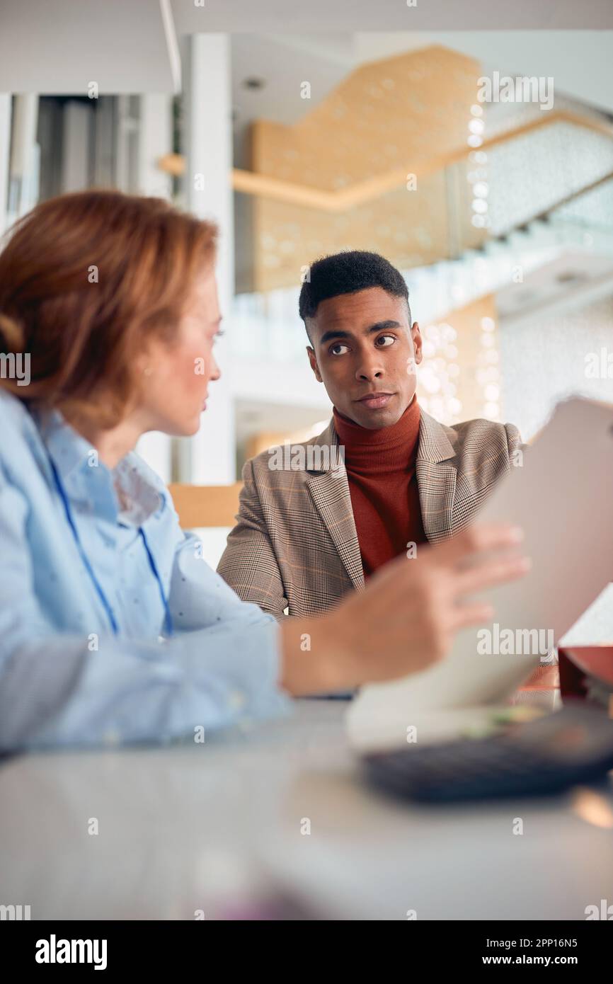 Two business colleagues in a working atmosphere at the office talking ...