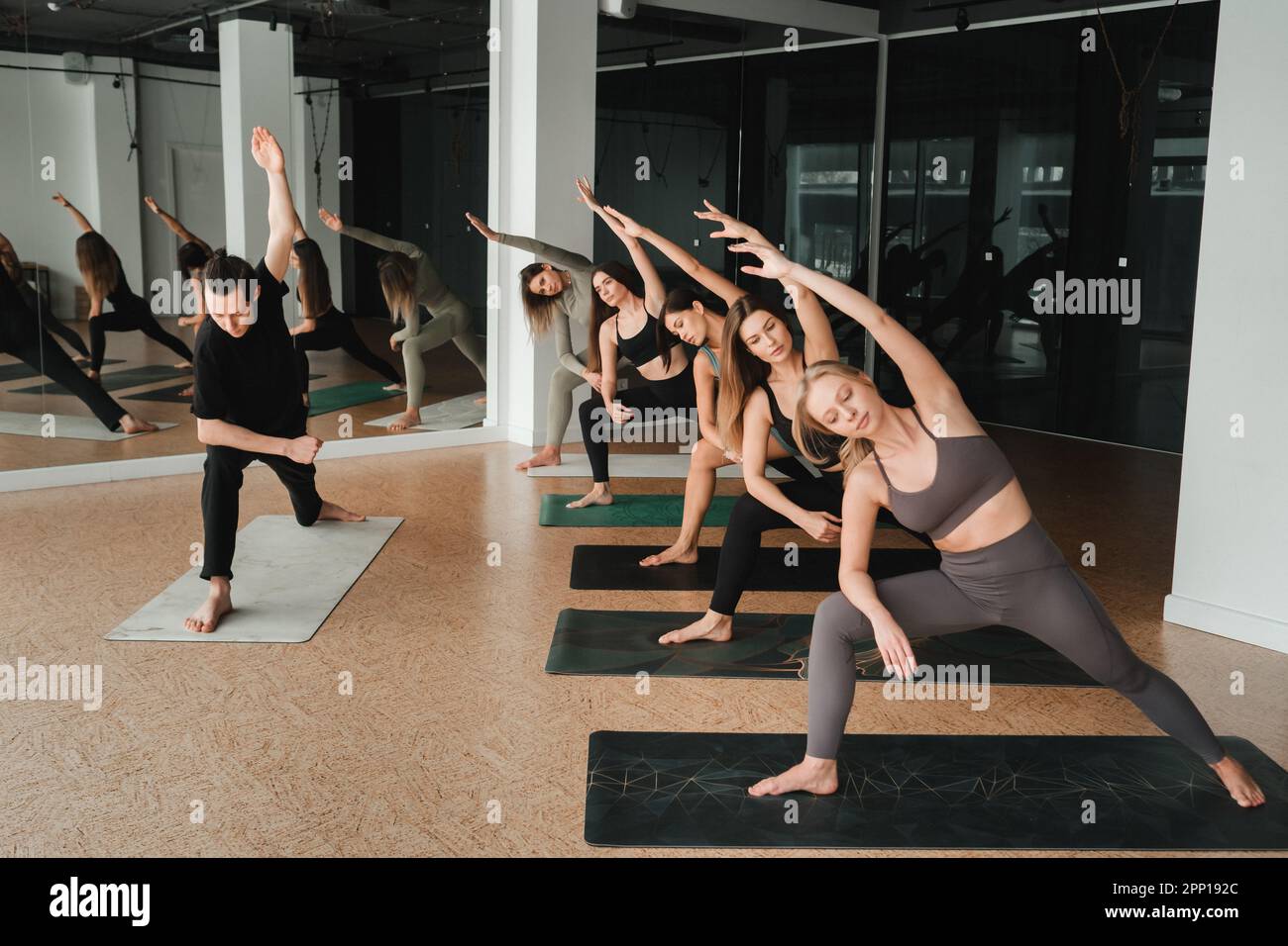 a group of girls do yoga in the gym under the guidance of a coach Stock ...