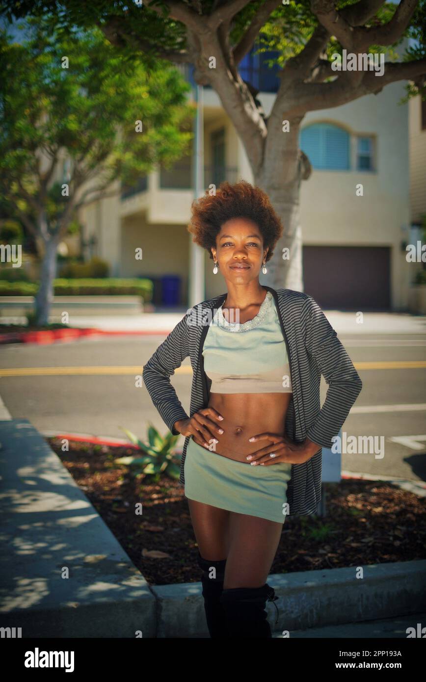 Beautiful Black woman standing on the sidewalk in Manhattan Beach ...