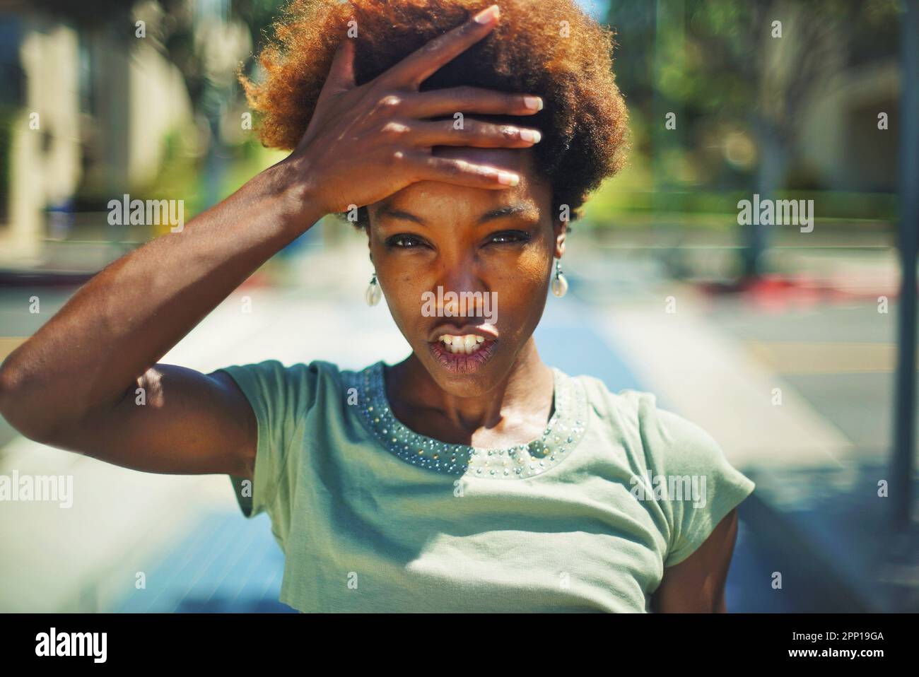 Beautiful Black woman standing on the sidewalk in Manhattan Beach ...