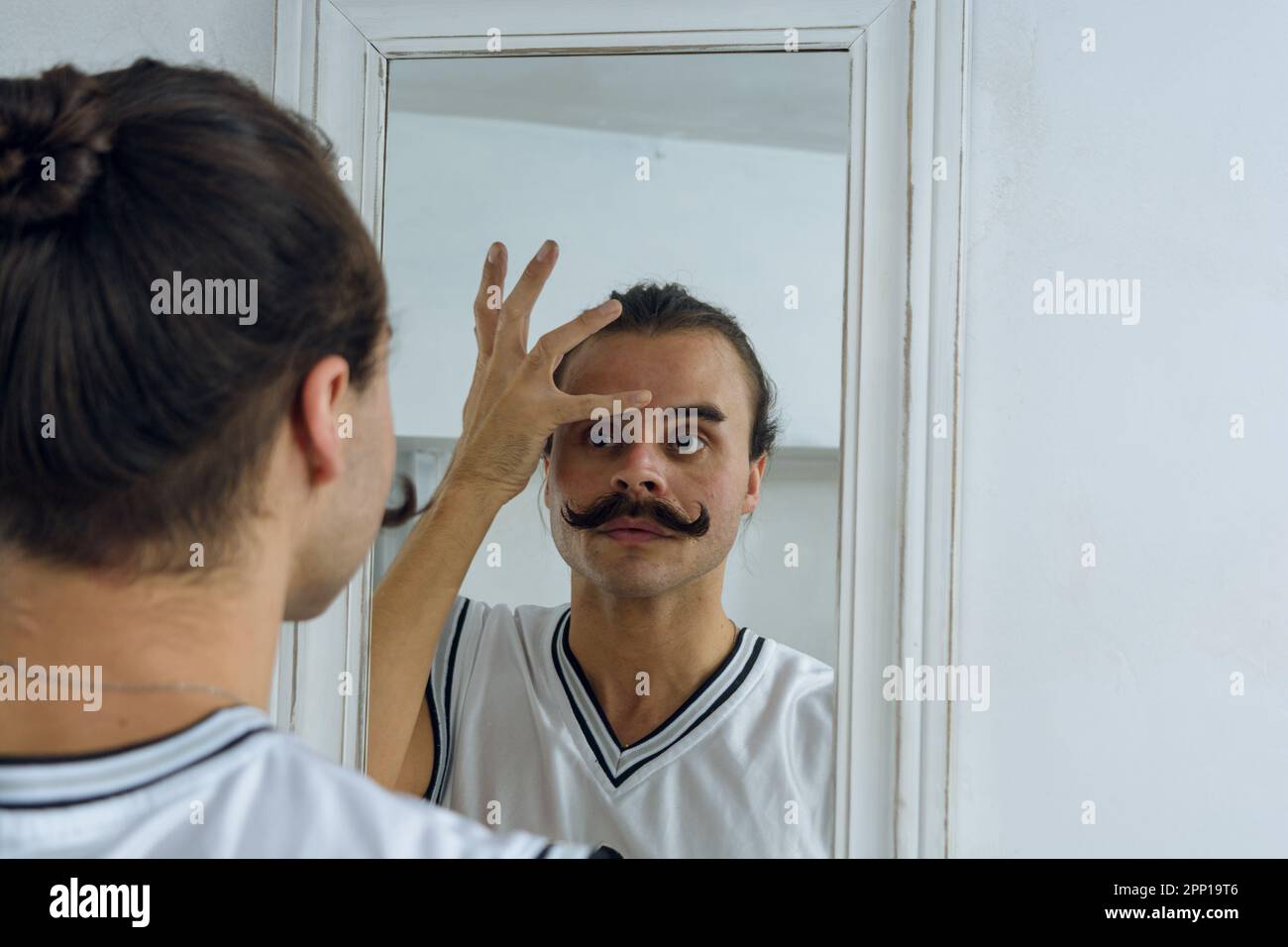 Non-binary Argentinian Latino person, with a mustache, is standing in ...