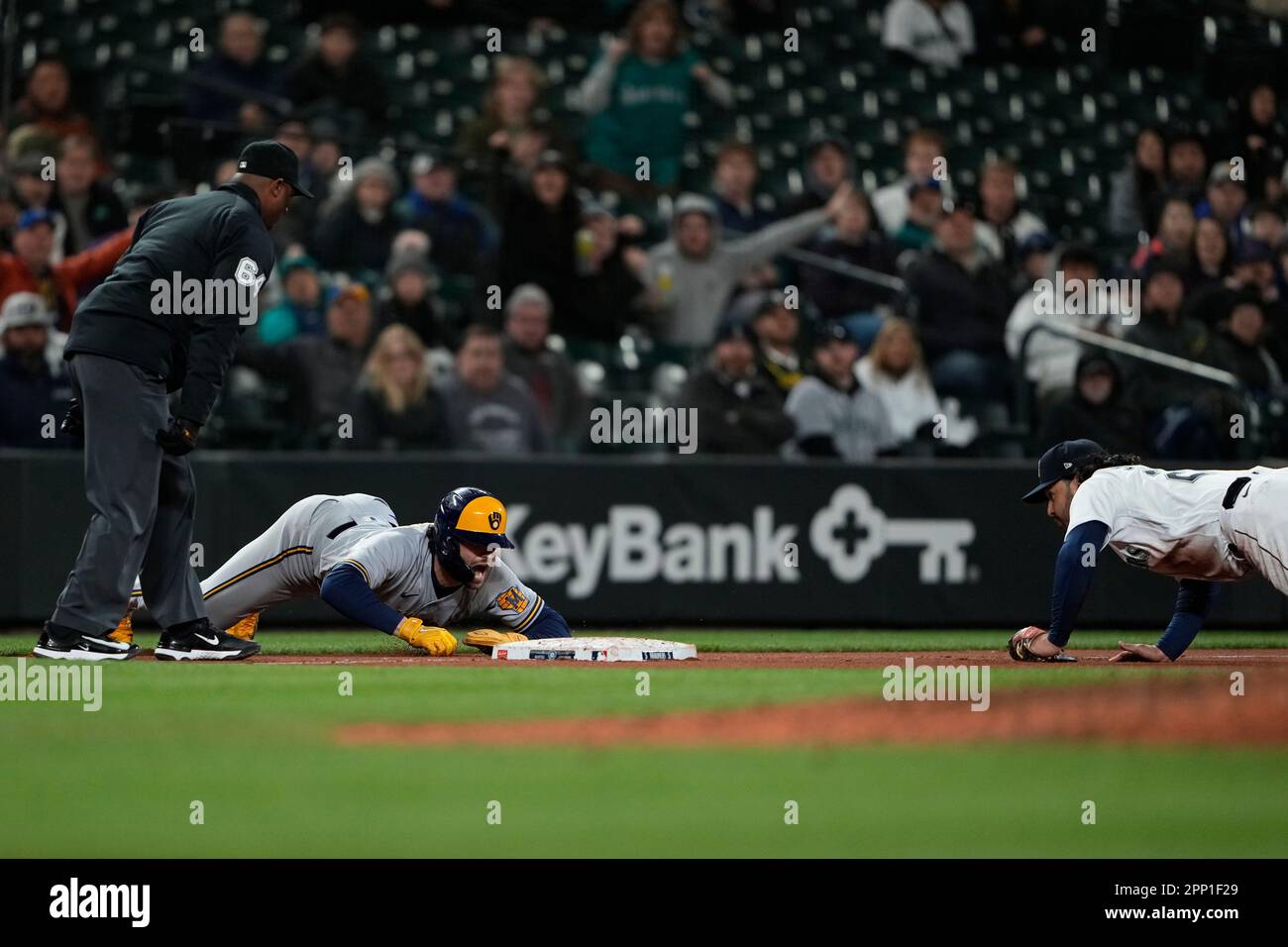 Milwaukee Brewers' Garrett Mitchell, left, reacts as he injures his ...