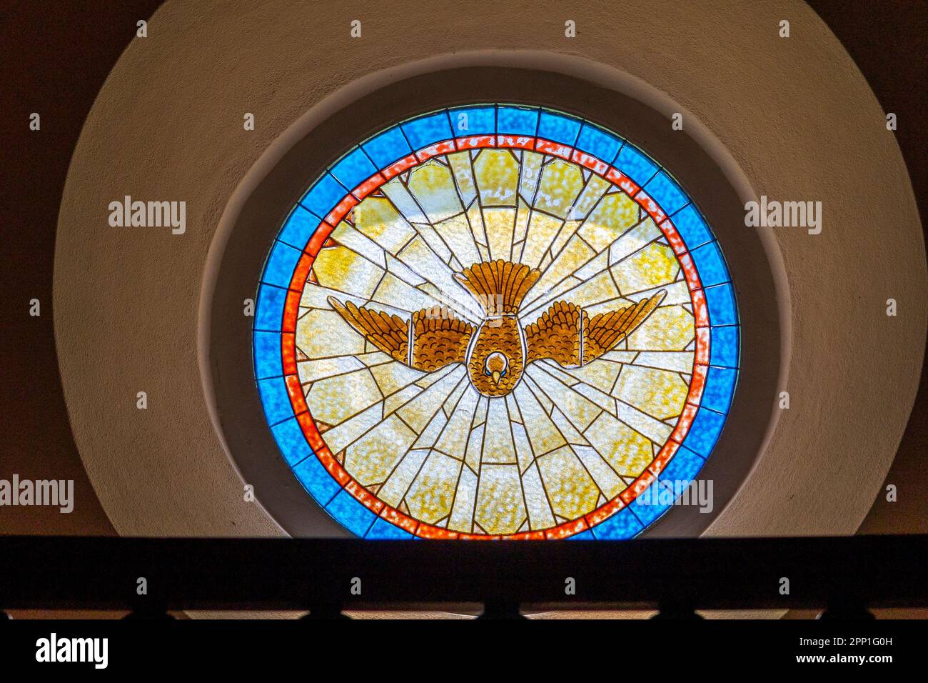 Stained Glass Window With Some Kind Of Bird Or Dove Depicted Inside A Christian Church In
