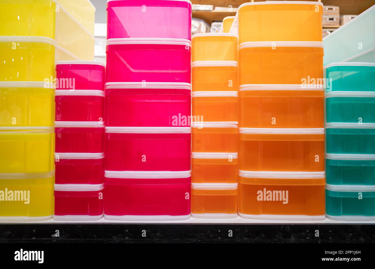Rows of multi-colored storage bin totes in a retail store shelving ...