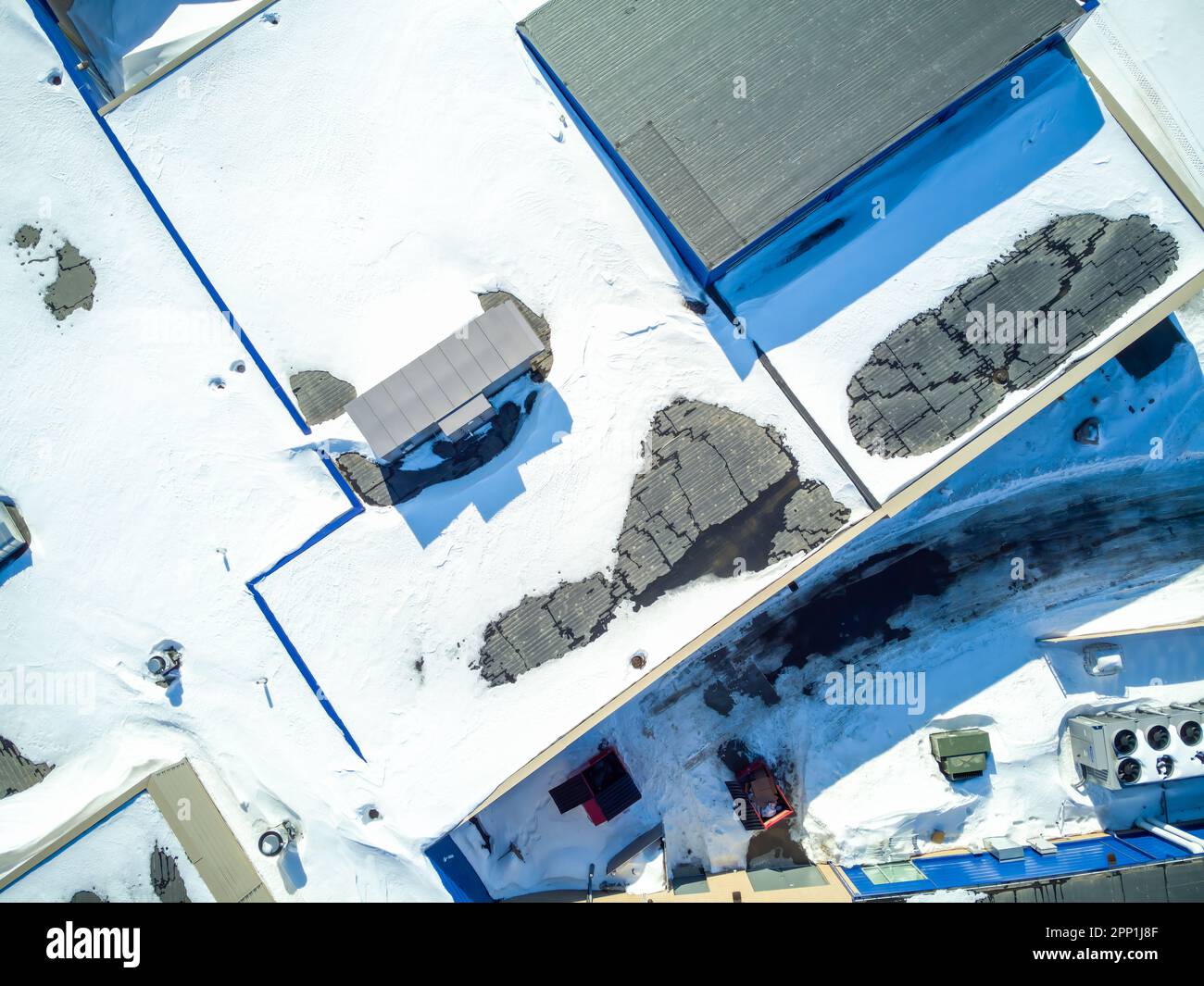 Elevated overhead drone view of a flat roofed building with snow load ...