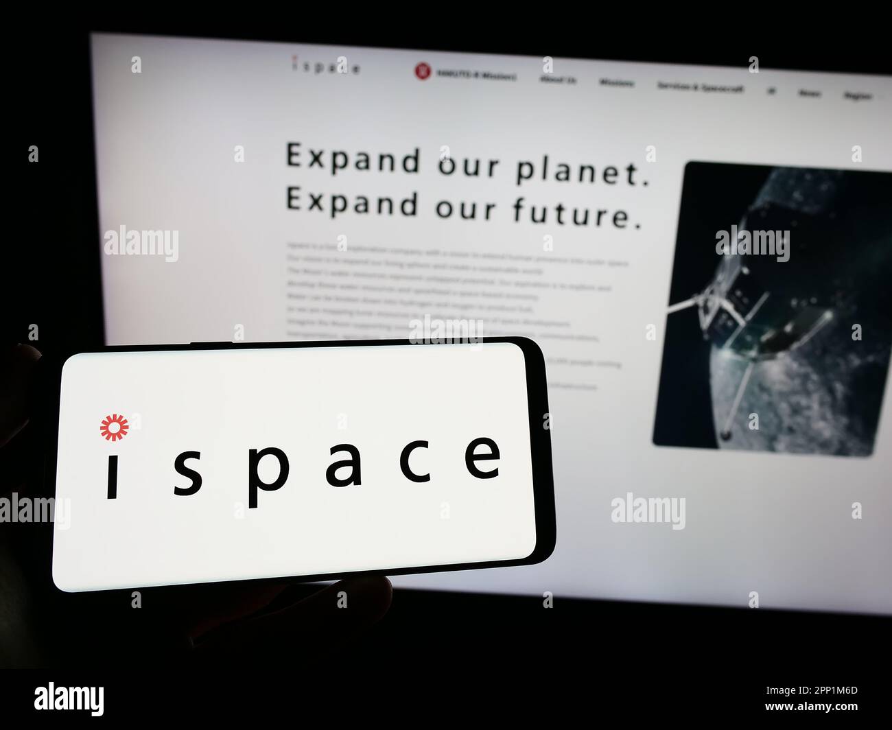 Person holding smartphone with logo of Japanese aerospace company ...