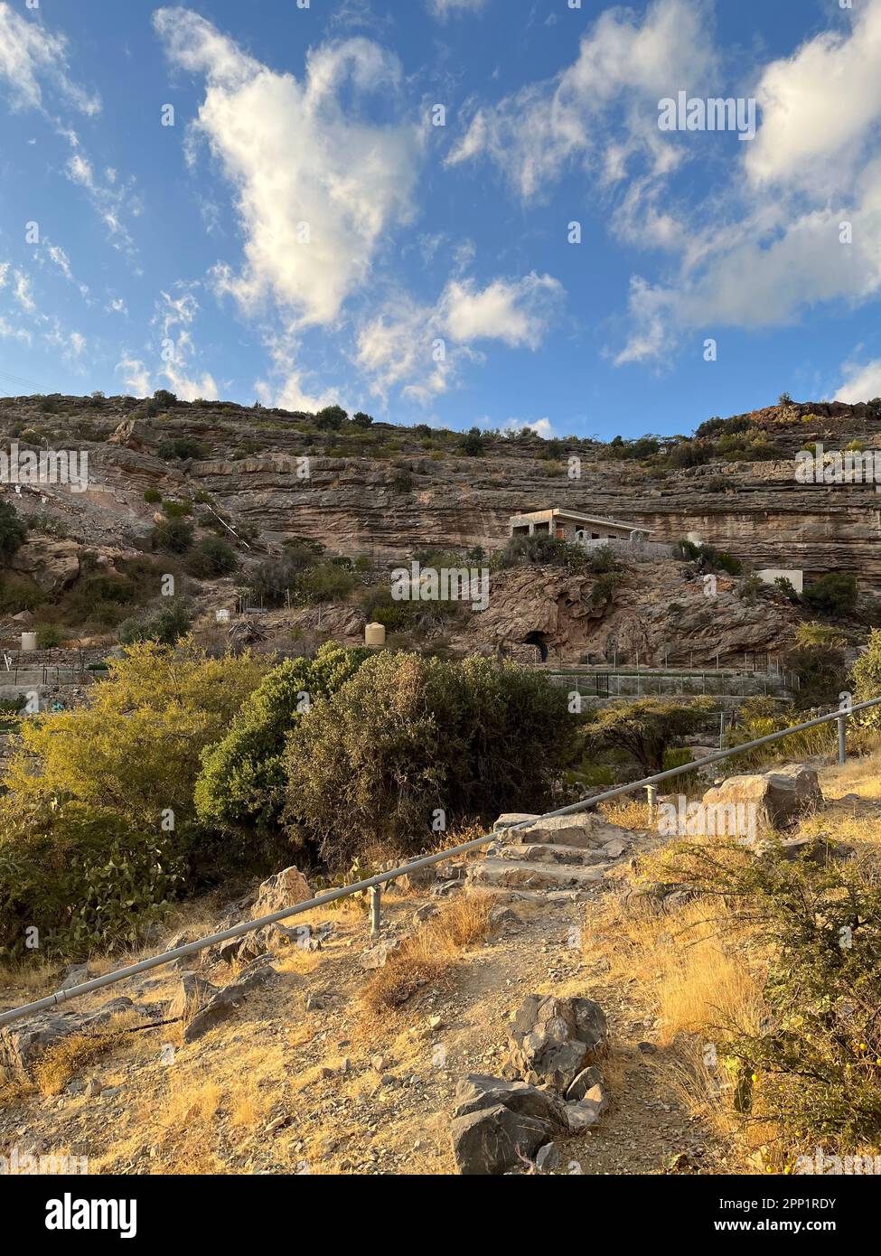An idyllic rural landscape featuring a rocky hillside, an empty valley ...