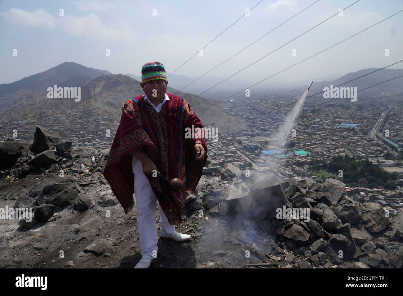 A shaman plays instrument as launches a firecracker during a ritual for ...