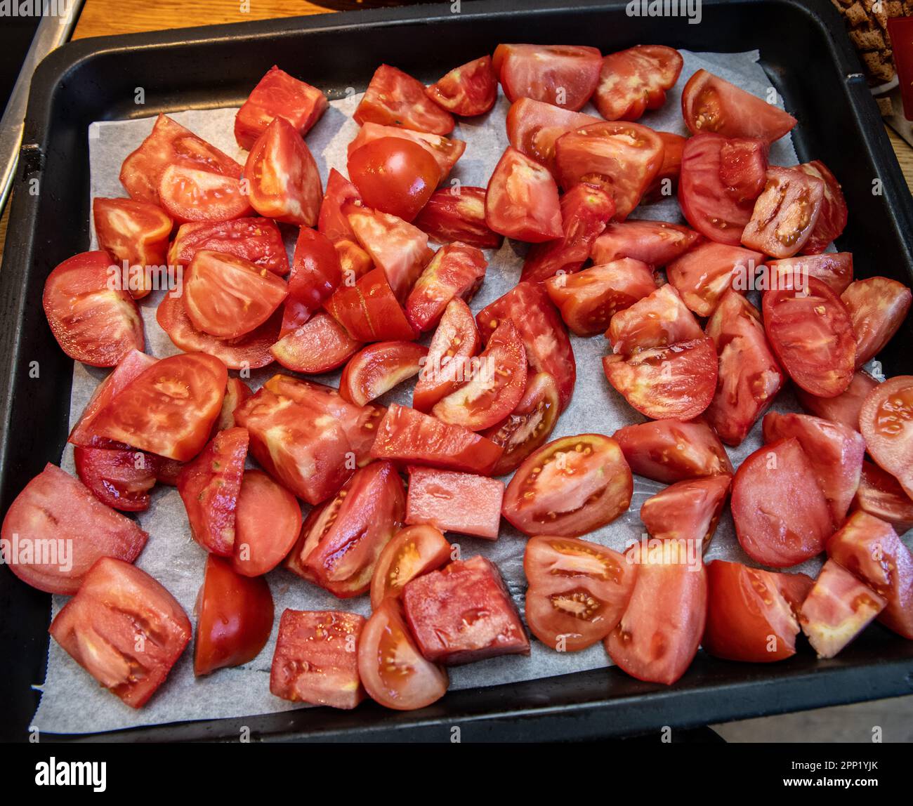 Pieces of cut up tomatoes on a stove plate Stock Photo - Alamy