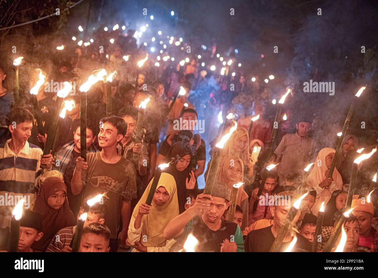 Participants hold torches during the Torch relay to welcome Eid al-Fitr ...