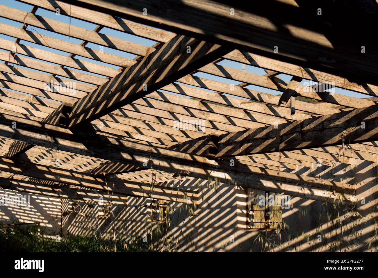 A wooden beam roof, attached to a building, constructed with wooden ...