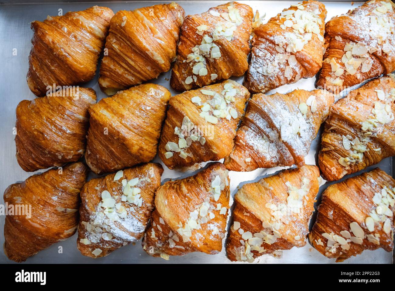 Sprinkle the finished croissants on a baking sheet with almond flakes ...
