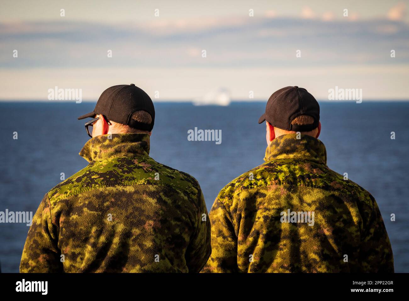 Two Canadian military personnel in camouflage uniform look into the ...