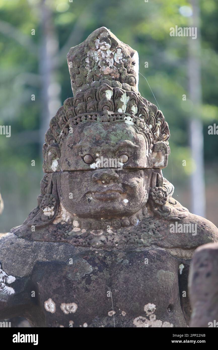 An antique statue standing majestically in the Angkor Wat temple ...
