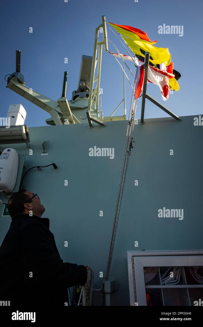 Sailor raising a hoist of signal flags onboard HMCS Margaret Brooke ...