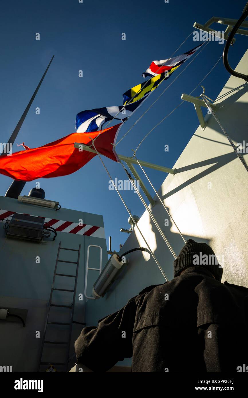 Sailor raising a hoist of signal flags onboard HMCS Margaret Brooke ...