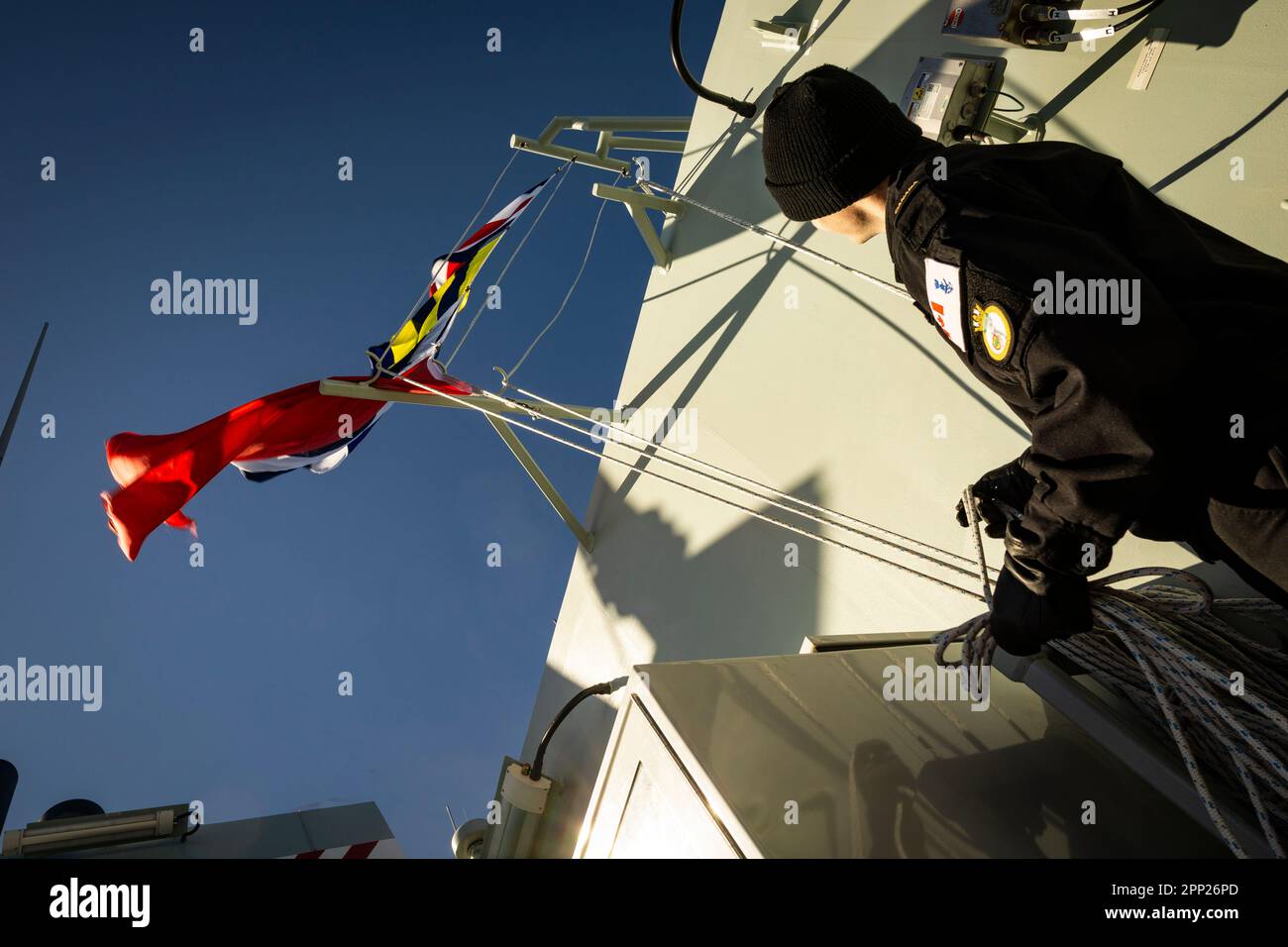 Sailor raising a hoist of signal flags onboard HMCS Margaret Brooke ...