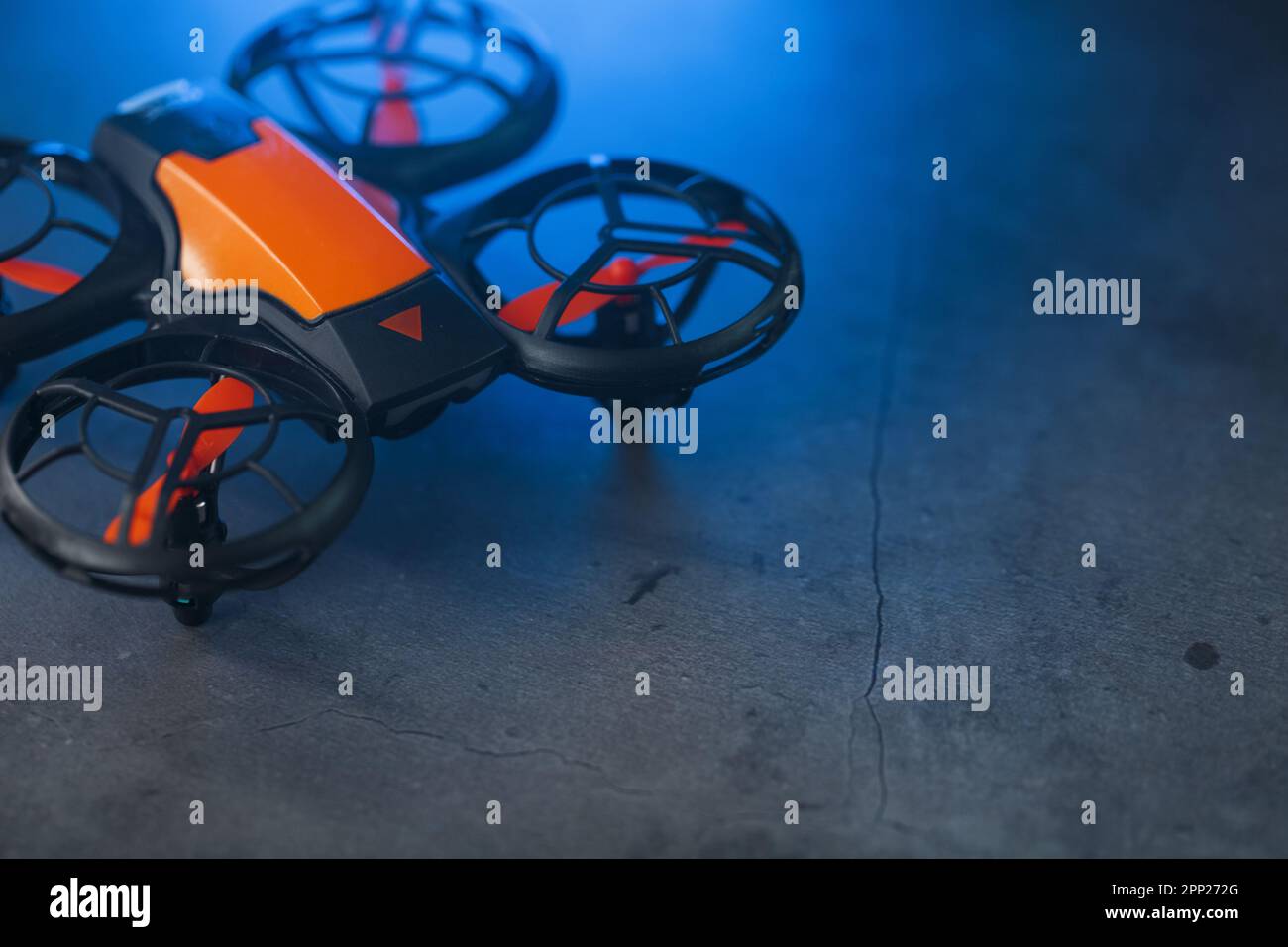 A reconnaissance quadcopter drone with an orange body and blue LED ...