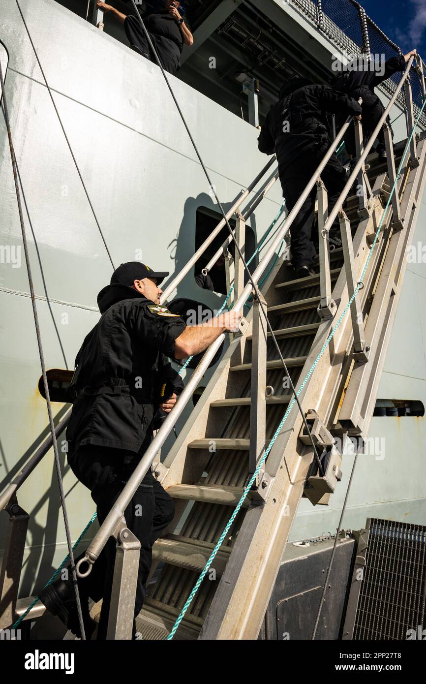 Crew members onboard HMCS Margaret Brooke stand at the rail watching ...