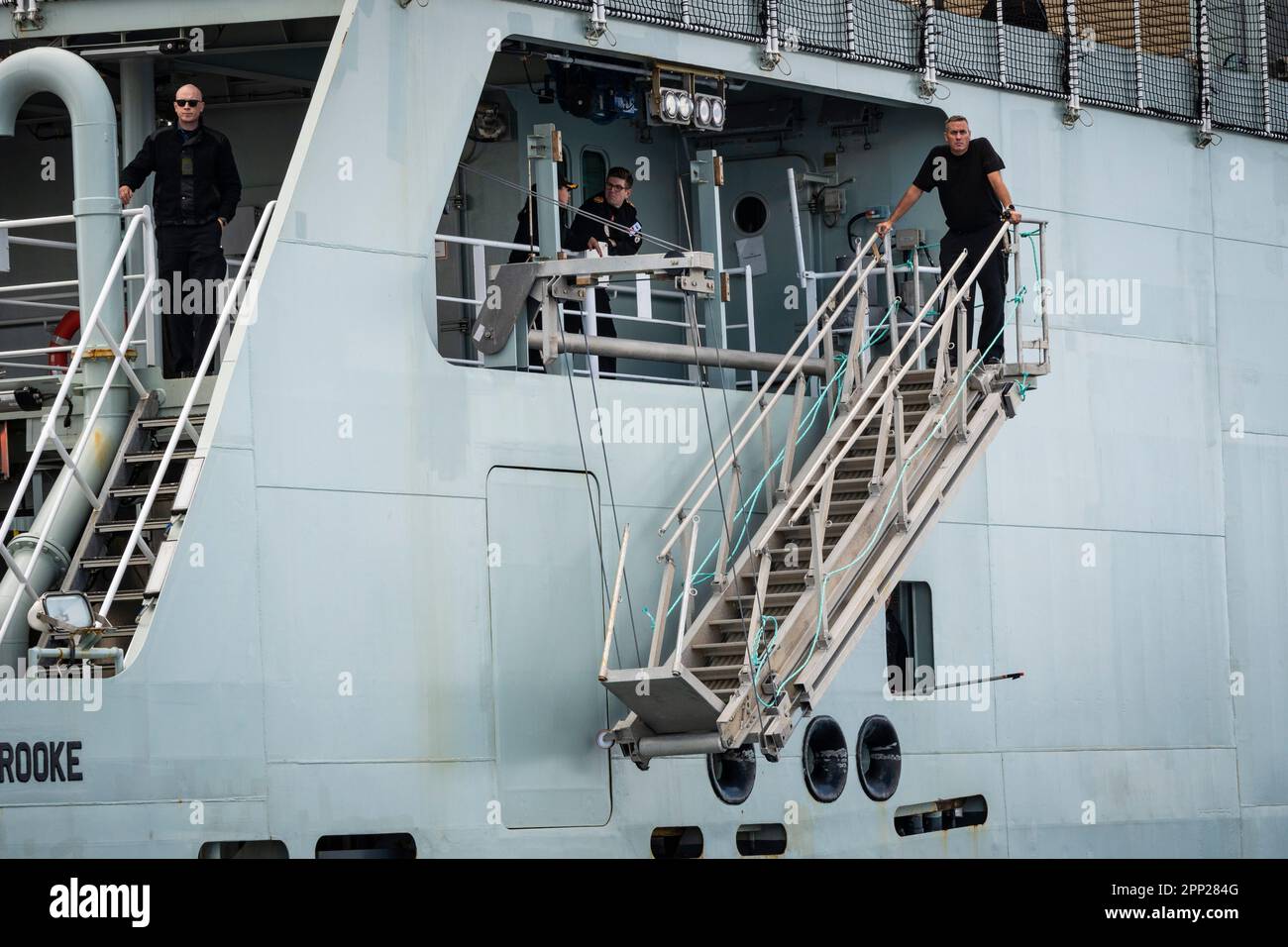 Crew members onboard HMCS Margaret Brooke stand at the rail watching ...
