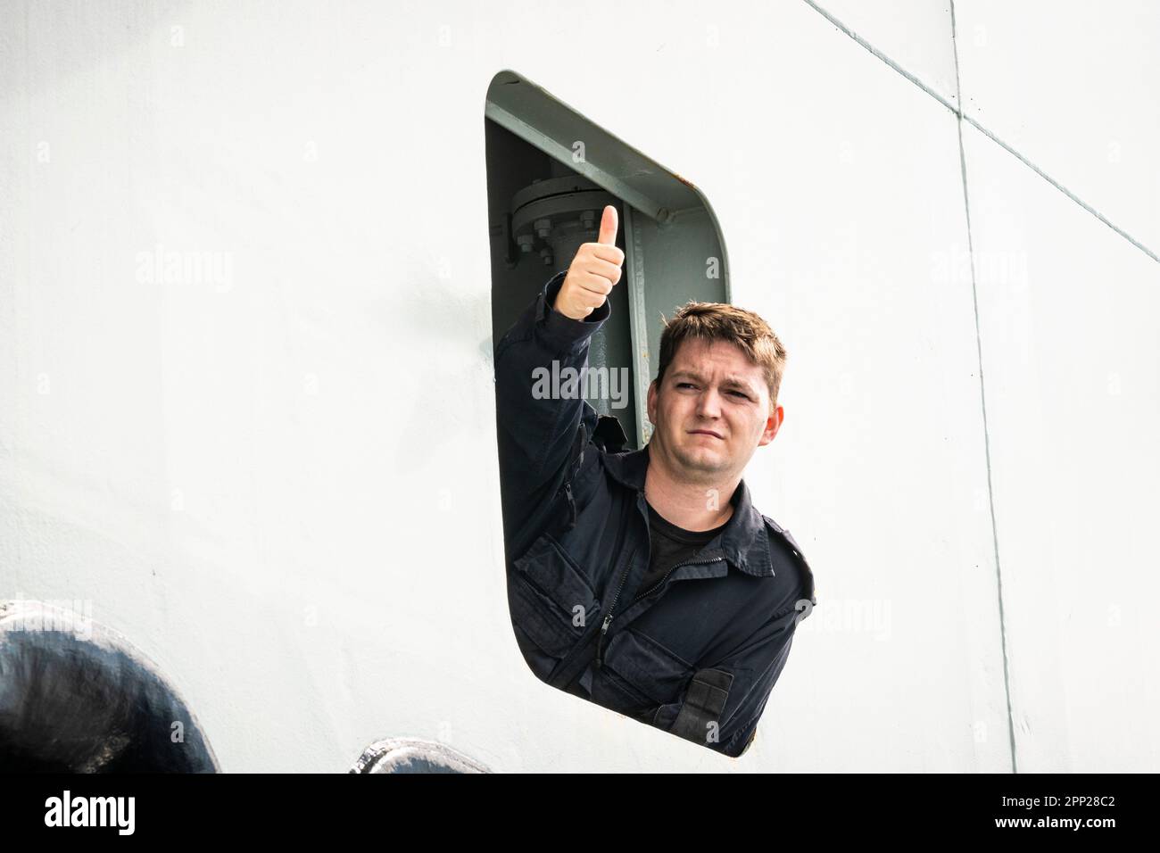 Crew members onboard HMCS Margaret Brooke stand at the rail watching ...
