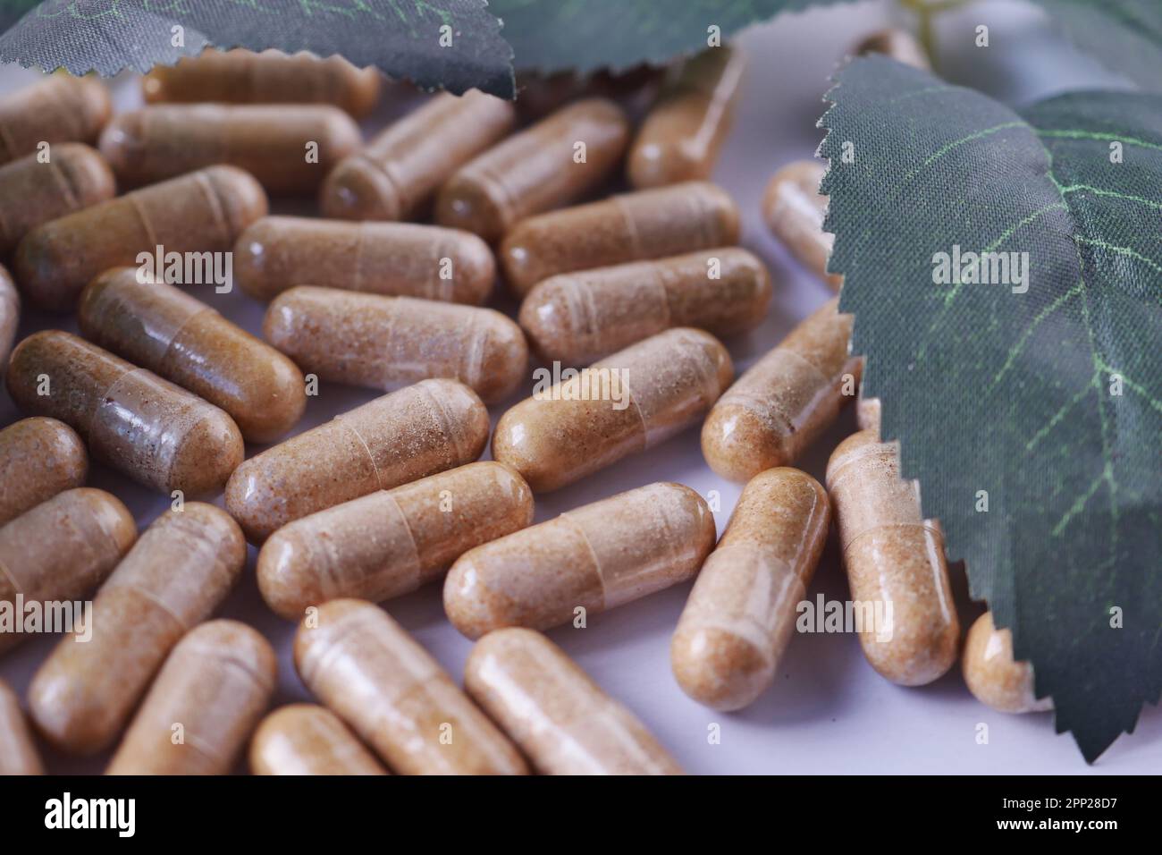 top view of herbal medicine capsule dropping on table Stock Photo - Alamy